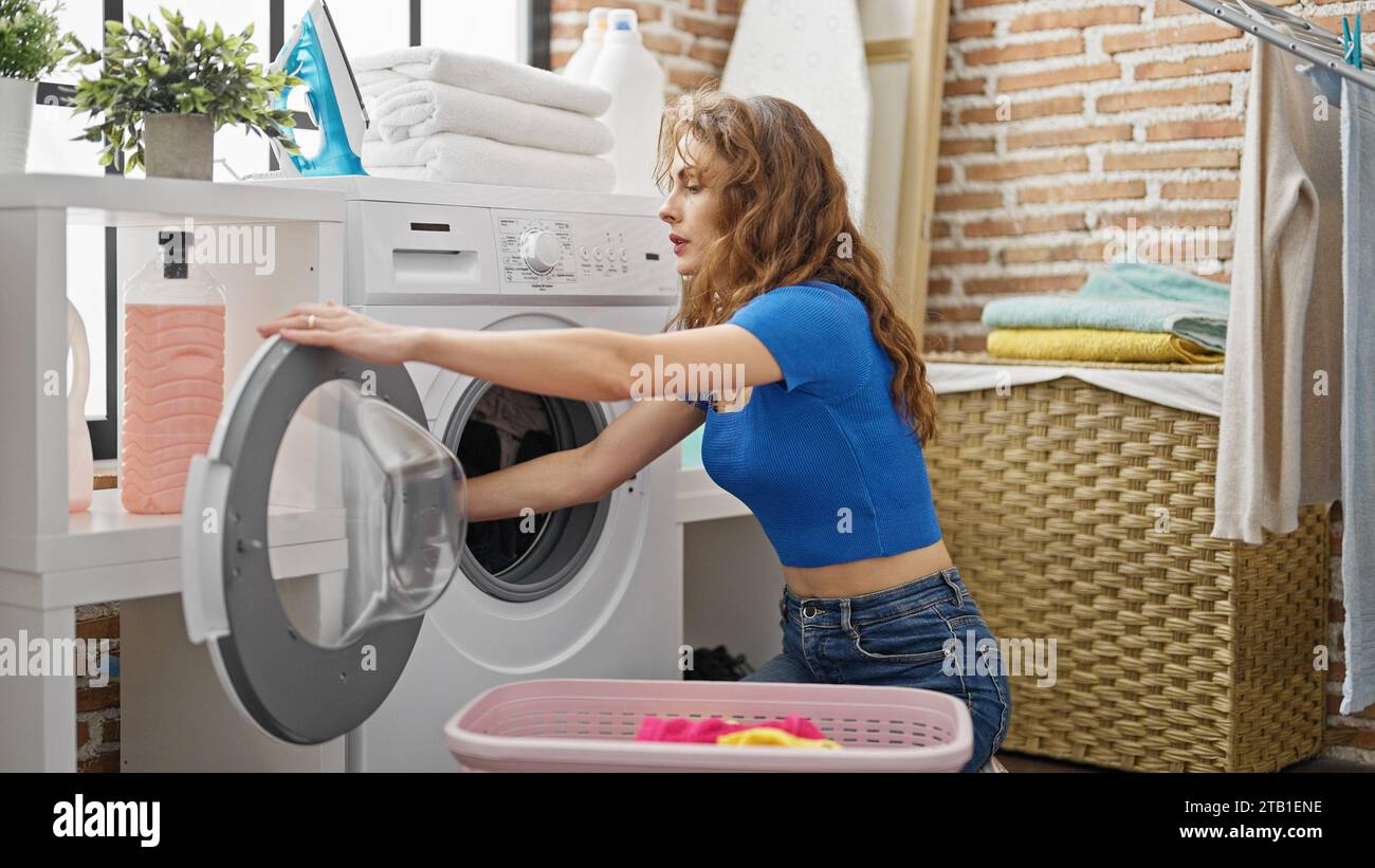 Young woman washing clothes at laundry room Stock Photo - Alamy