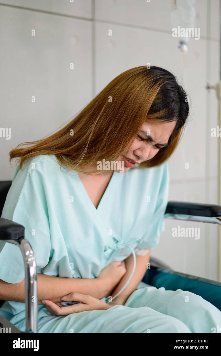 Woman patient on wheelchair having stomach ache in hospital Stock Photo ...