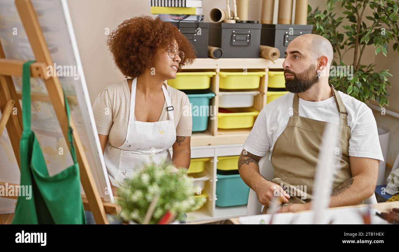 At the art studio, two smiling artists, partners in creativity, sitting ...