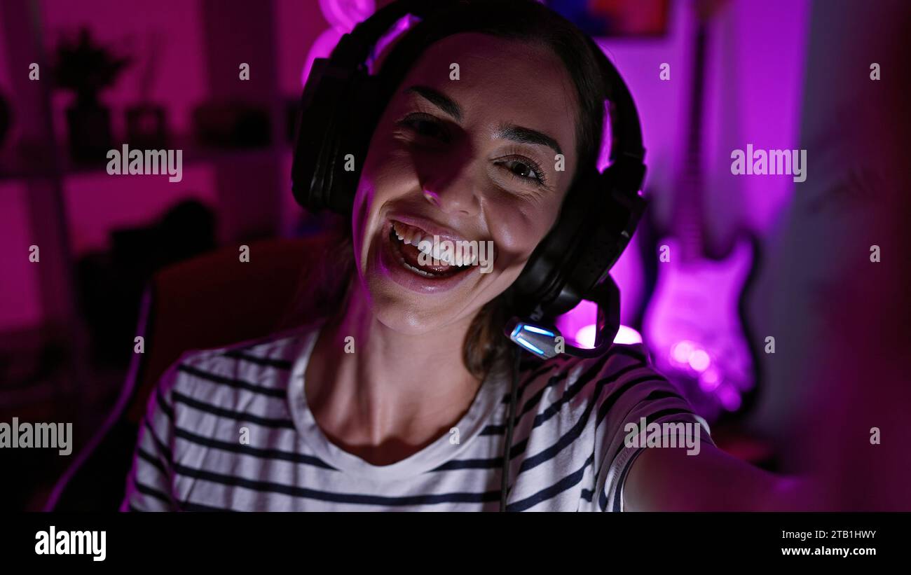 Smiling young hispanic woman streamer confidently navigates digital ...