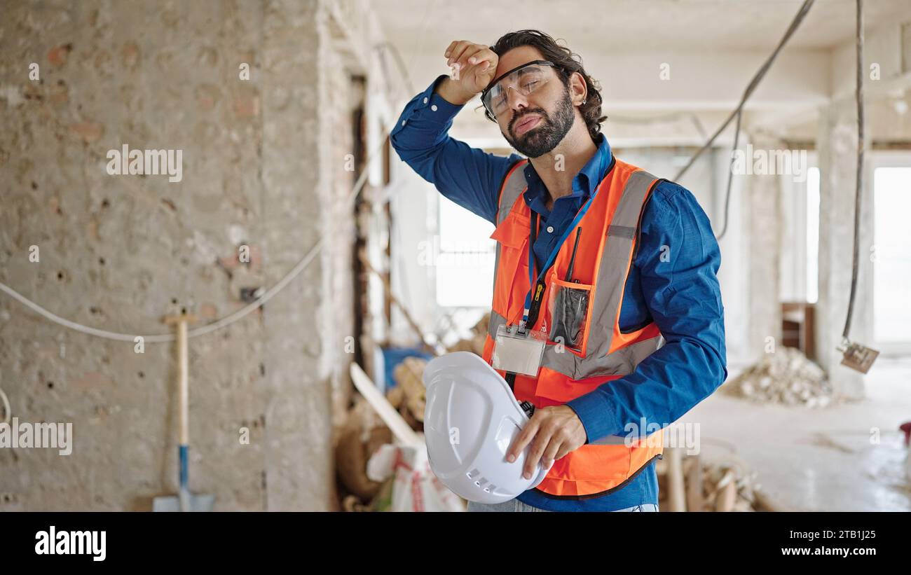 Young hispanic man architect sweating at construction site Stock Photo ...