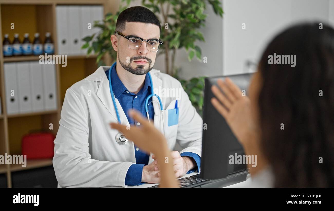 Doctor and patient, two people, sitting together at clinic table in ...
