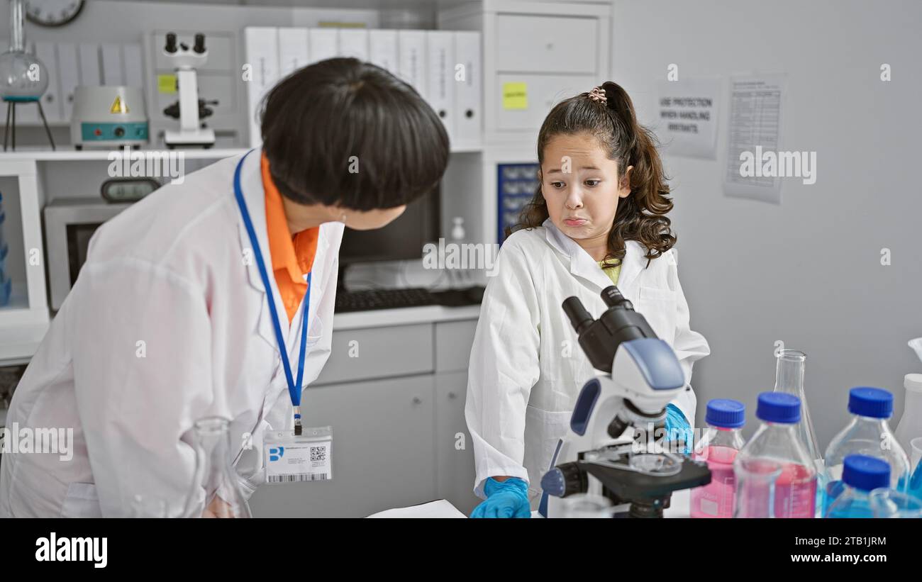 Two serious-faced scientist partners standing together, speaking about medical research analysis ...