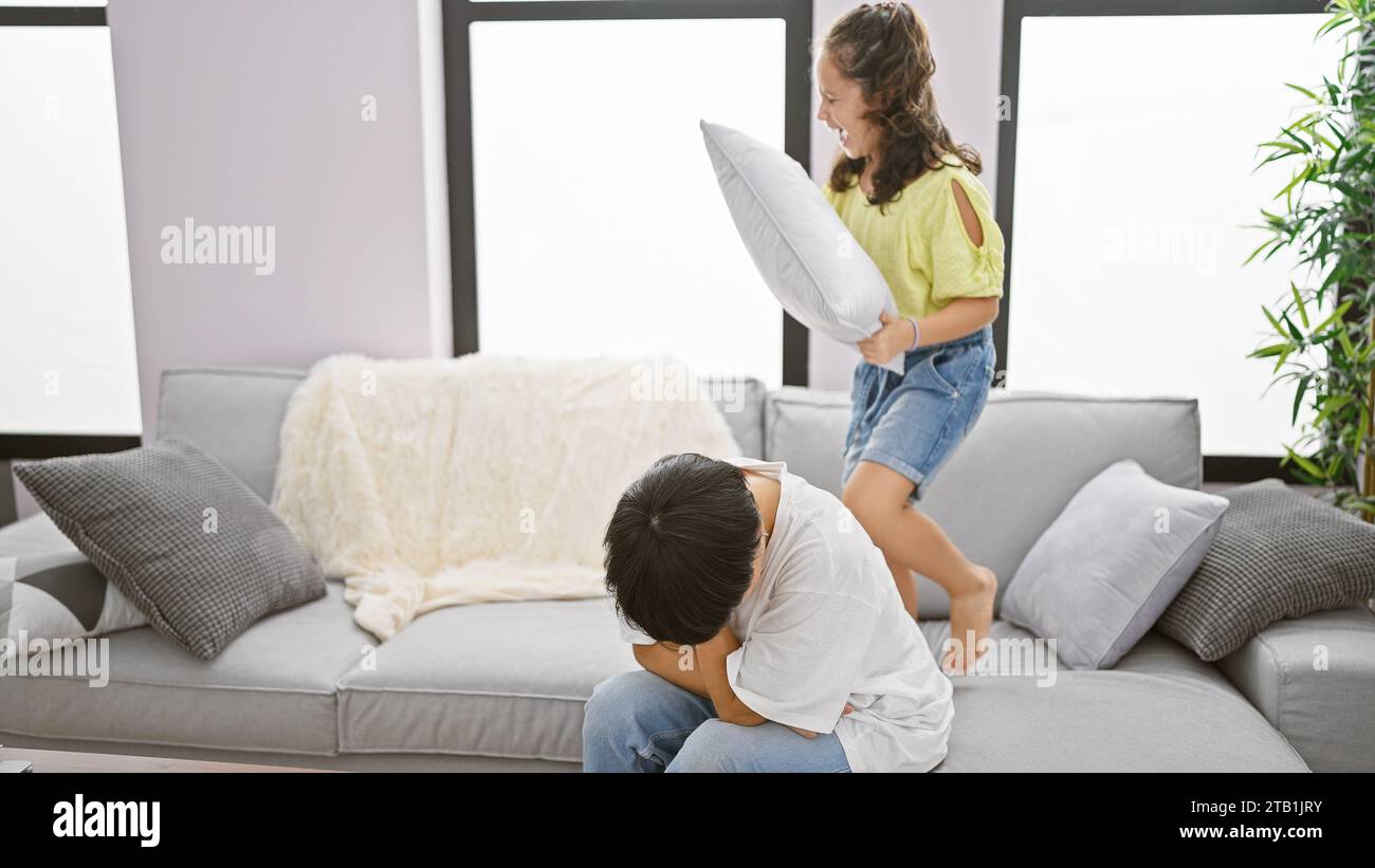Mother and daughter jumping on sofa, disturbing home's relaxed ...