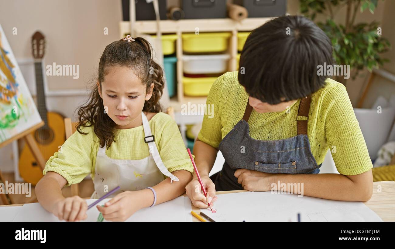 Artist teacher and student drawing on canvas together in art studio ...