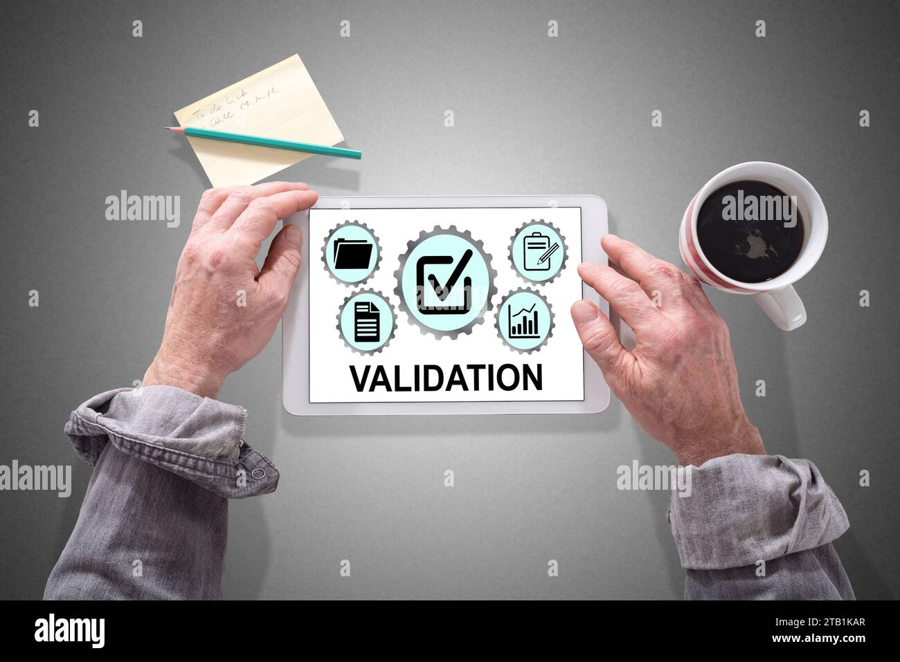 Male hands using a tablet showing validation concept Stock Photo - Alamy