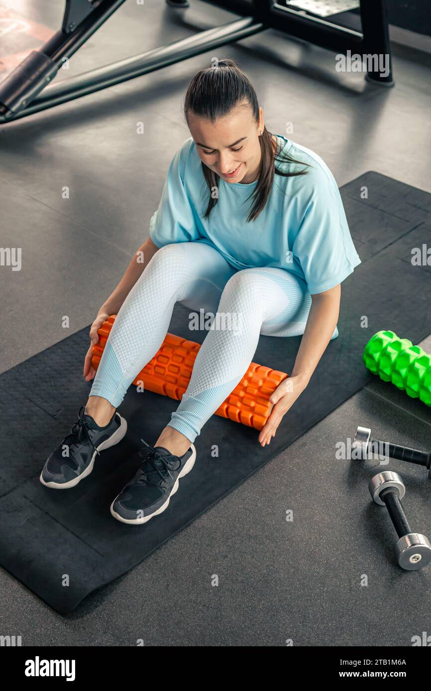 Sport woman using foam roller for muscle and fascia stretching foot ...