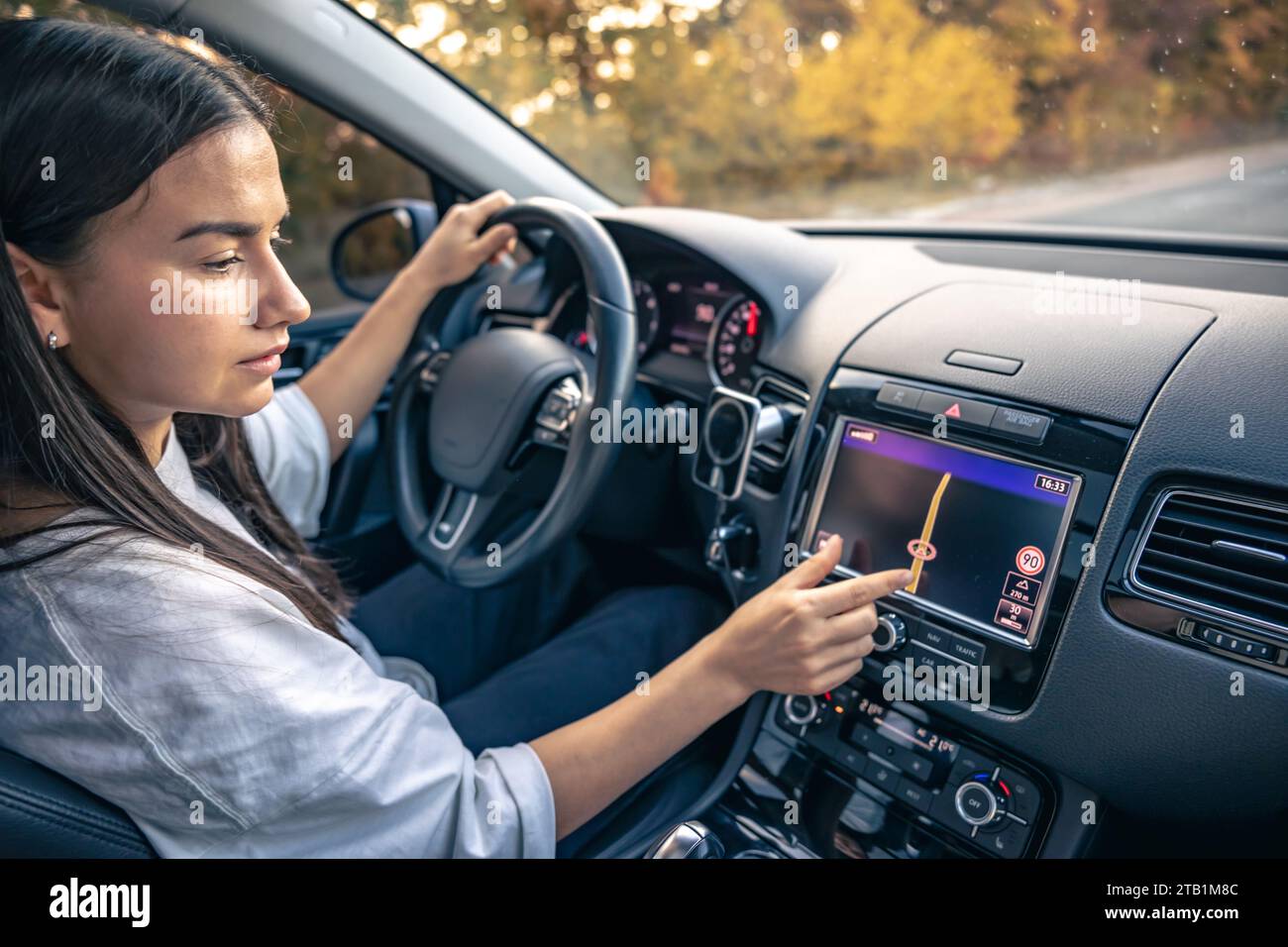 Woman using navigation system while driving a car Stock Photo - Alamy