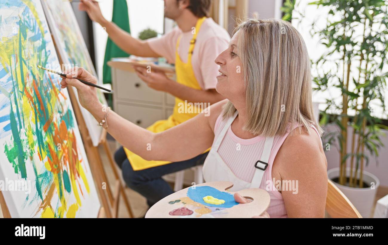 Two confident artists, man and woman, enjoy drawing together with ...