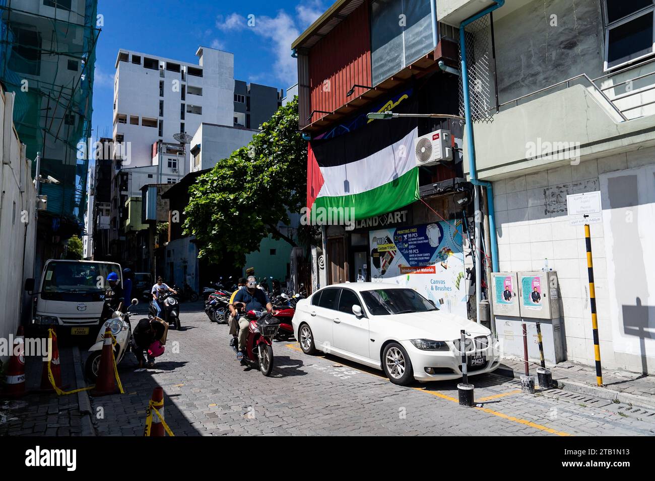Maldives. 04th Dec, 2023. People drive a motorcycle past a large ...