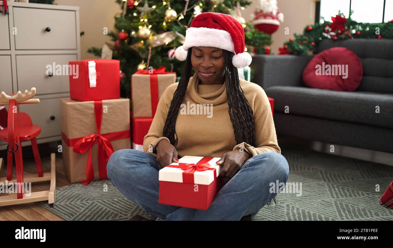 African woman unpacking gift sitting hi-res stock photography and ...