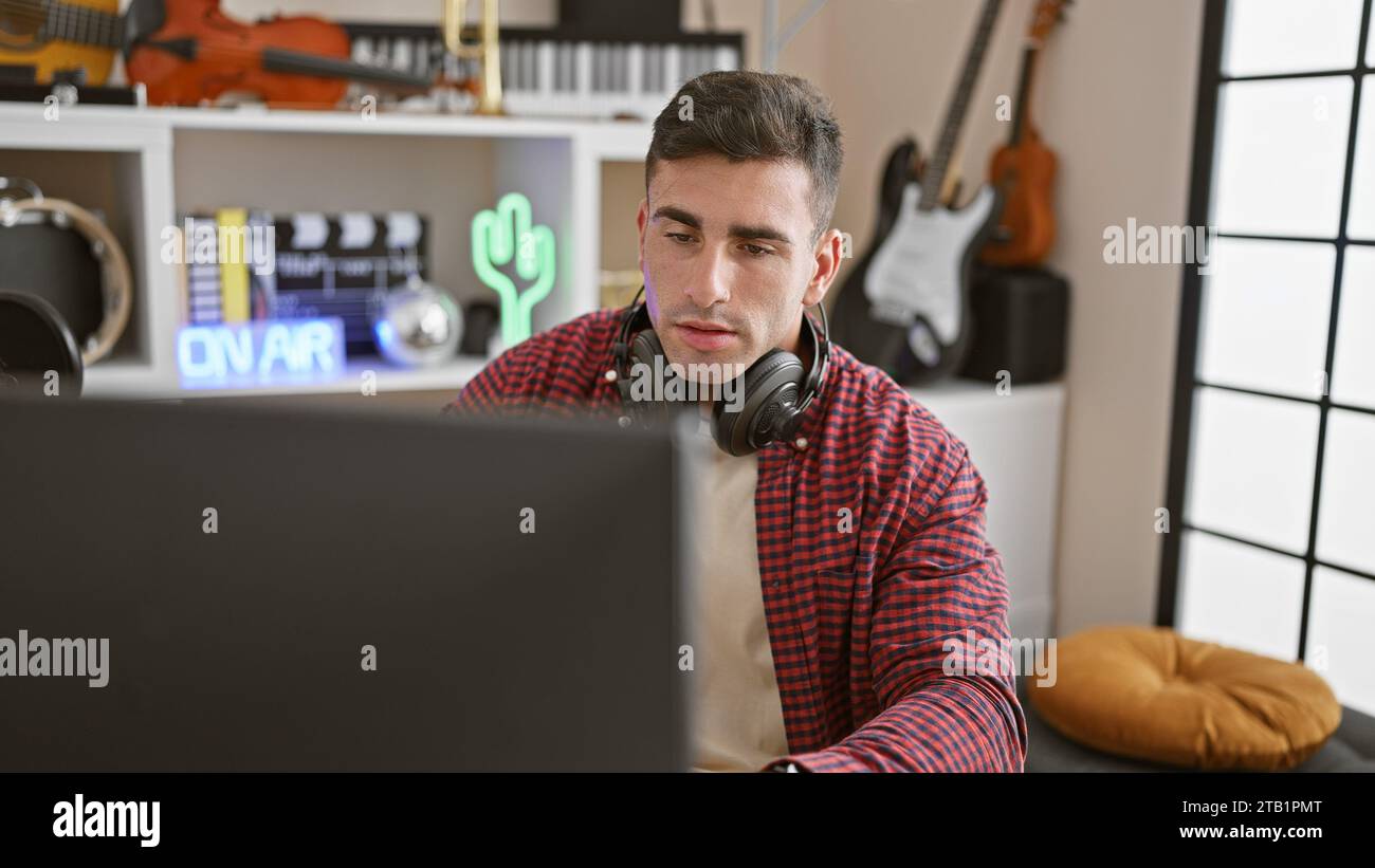 Stoic-faced young hispanic musician man, immersed deeply in crafting ...