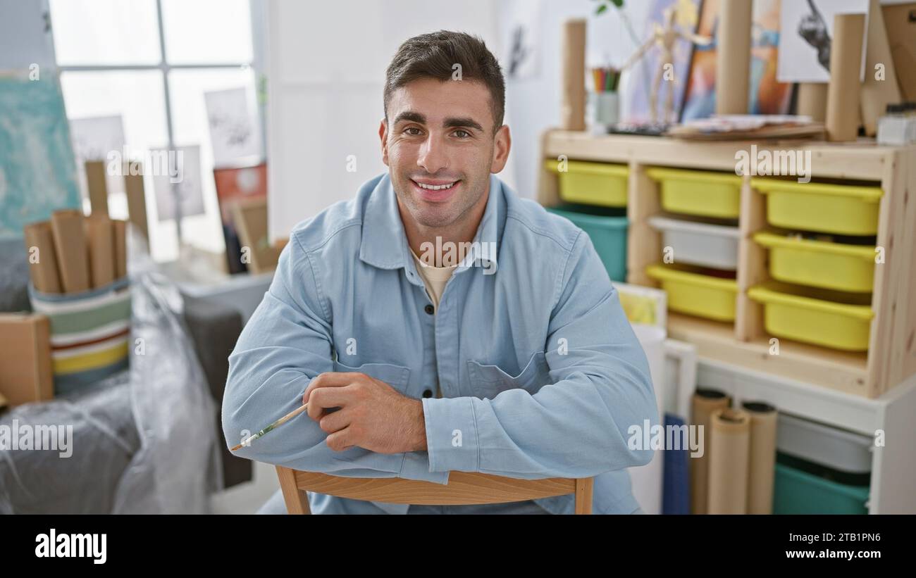 Confident young hispanic man and rising artist, smiling and holding a ...