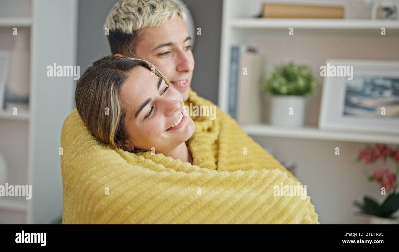 Beautiful couple covering with blanket hugging each other at home Stock ...