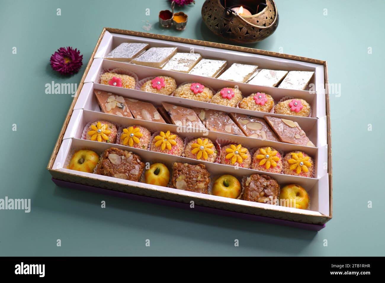 Indian assorted Diwali sweets or mithai with diya and flowers. Festive ...