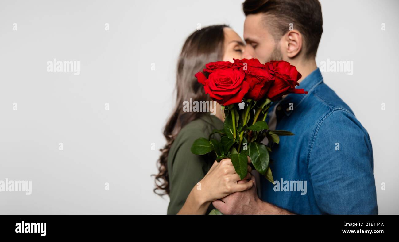 Close up photo of young beautiful stylish couple kisses behind a ...