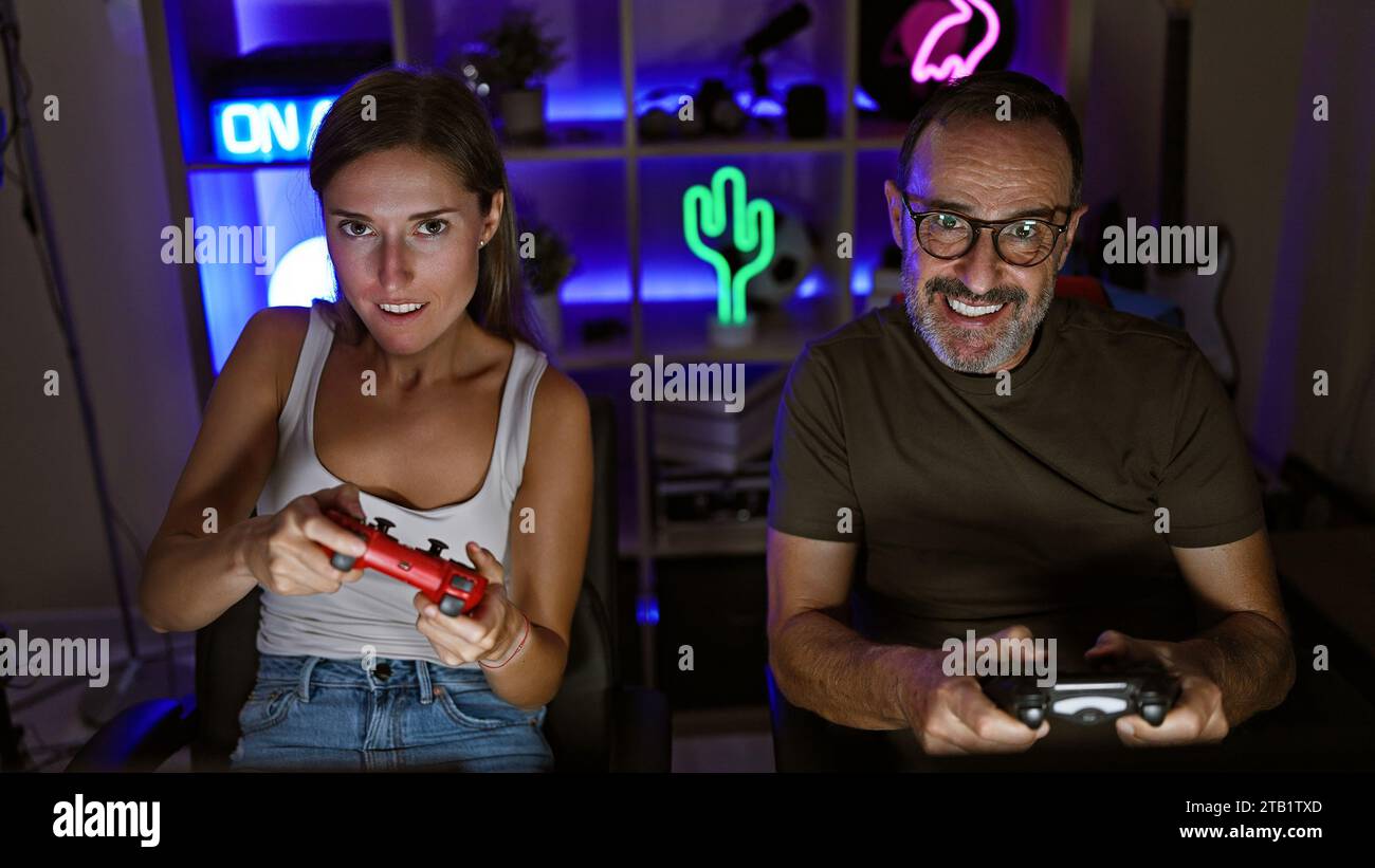 Two smiling gamers, journey into the gaming room, father and daughter ...