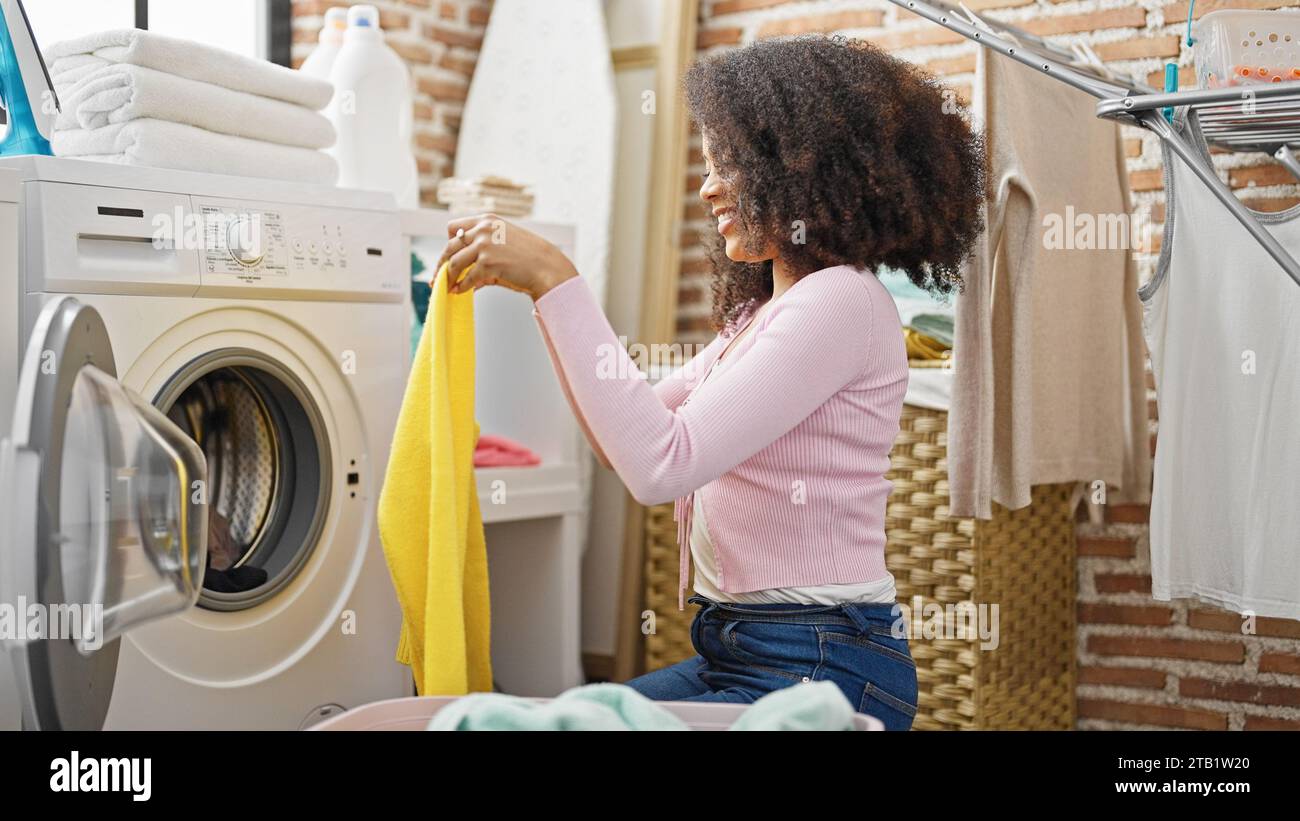 African american woman washing clothes smiling at laundry room Stock ...