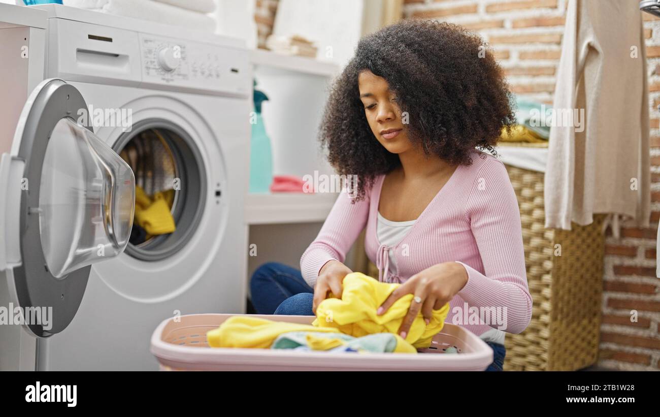 African american woman washing clothes at laundry room Stock Photo - Alamy
