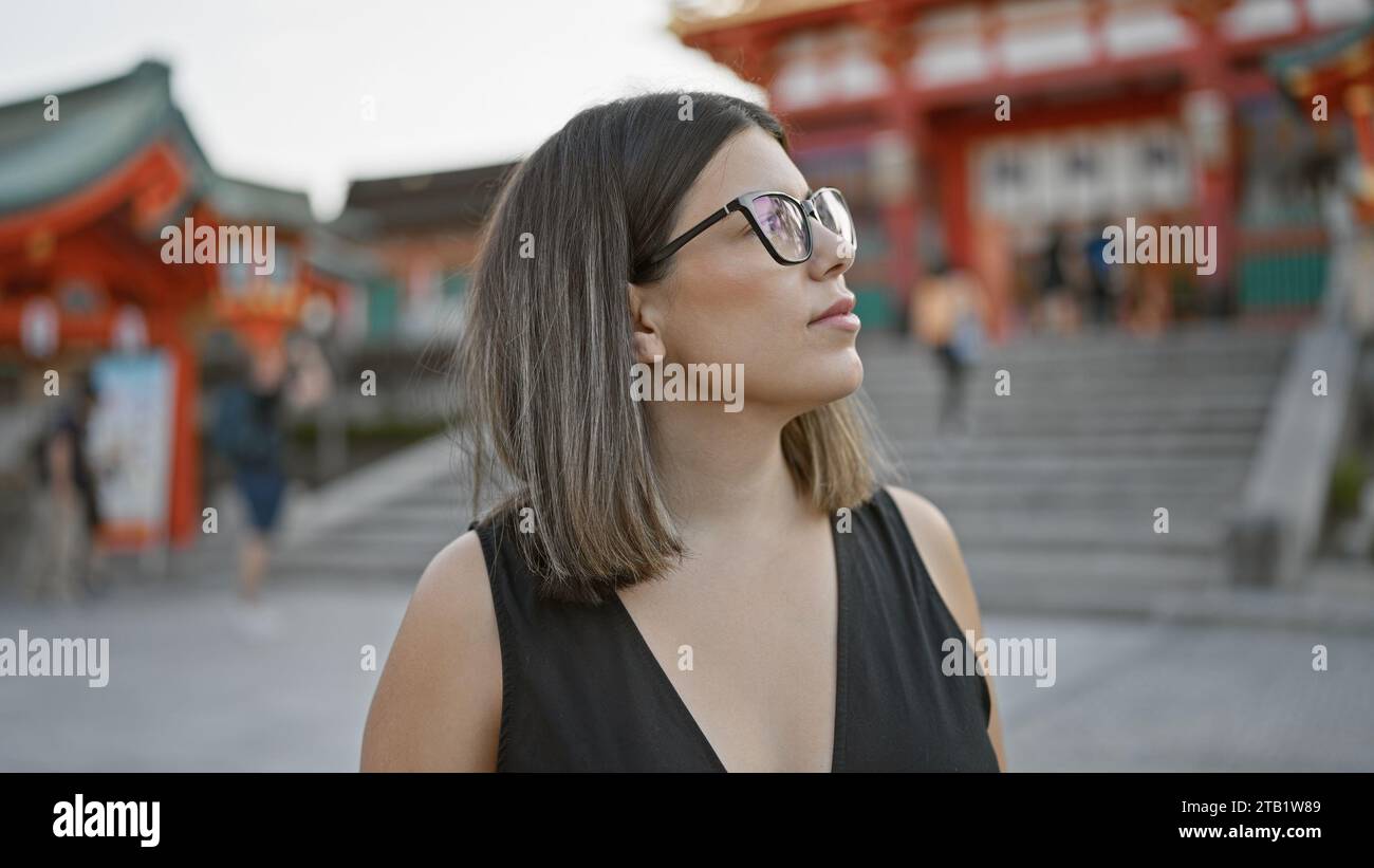Confidently posing at fushimi inari taisha, a beautiful hispanic woman ...