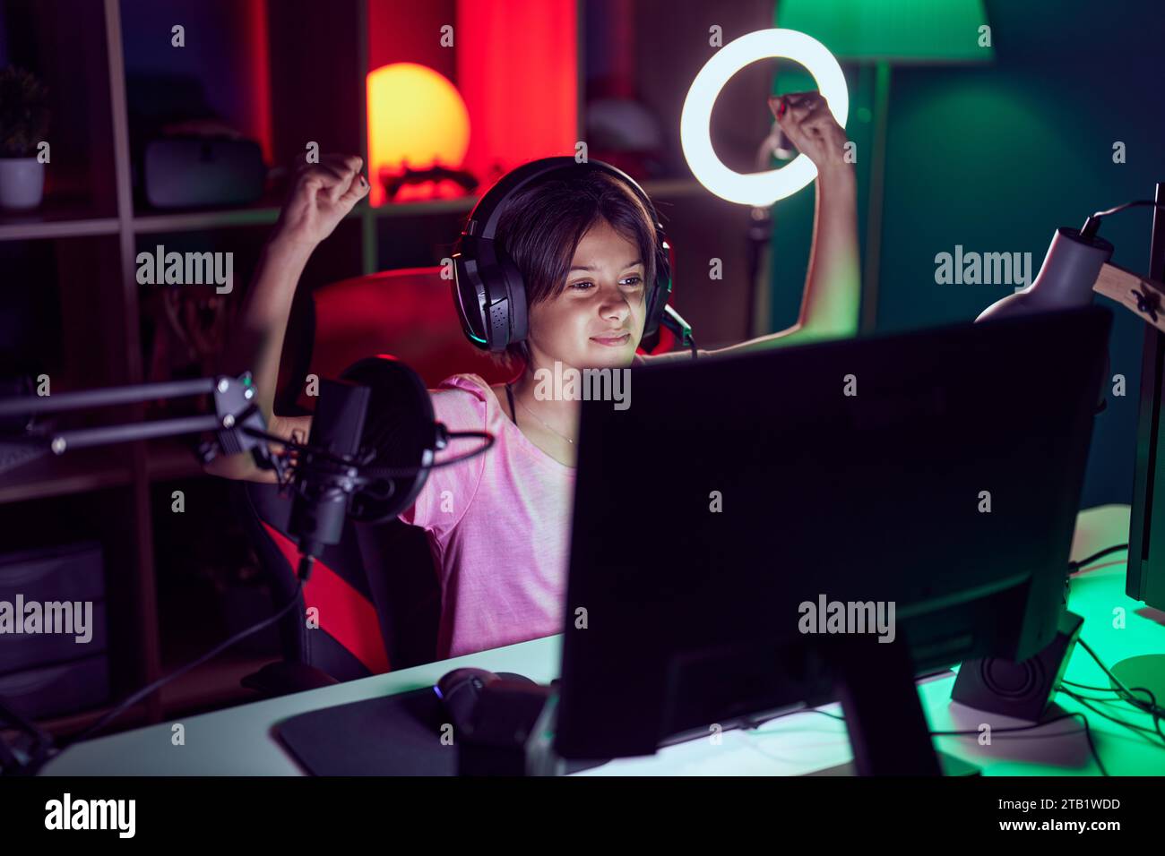 Adorable hispanic girl streamer playing video game with winner ...