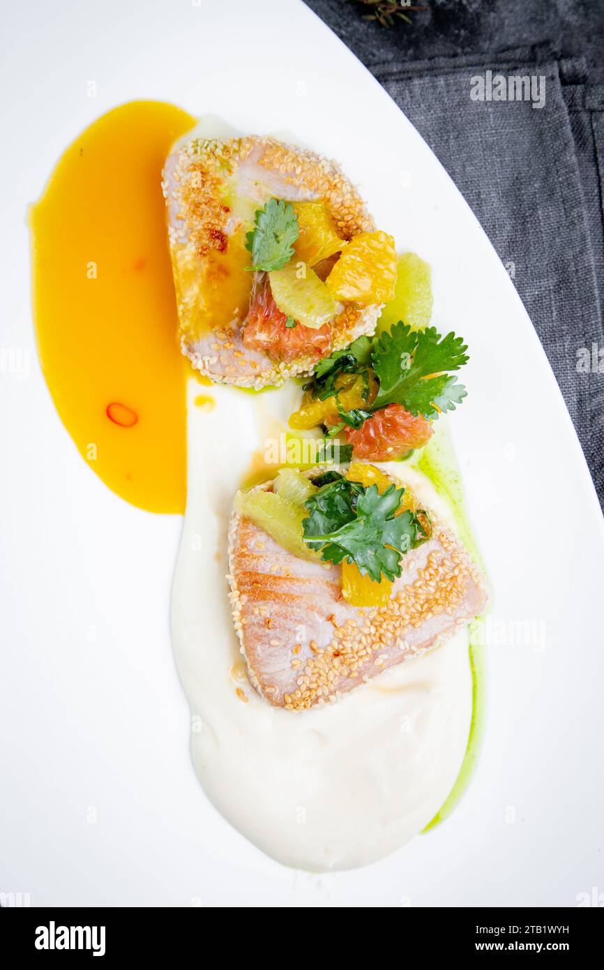 breaded fish fillet with pineapple, parsley and cream sauce, top view ...