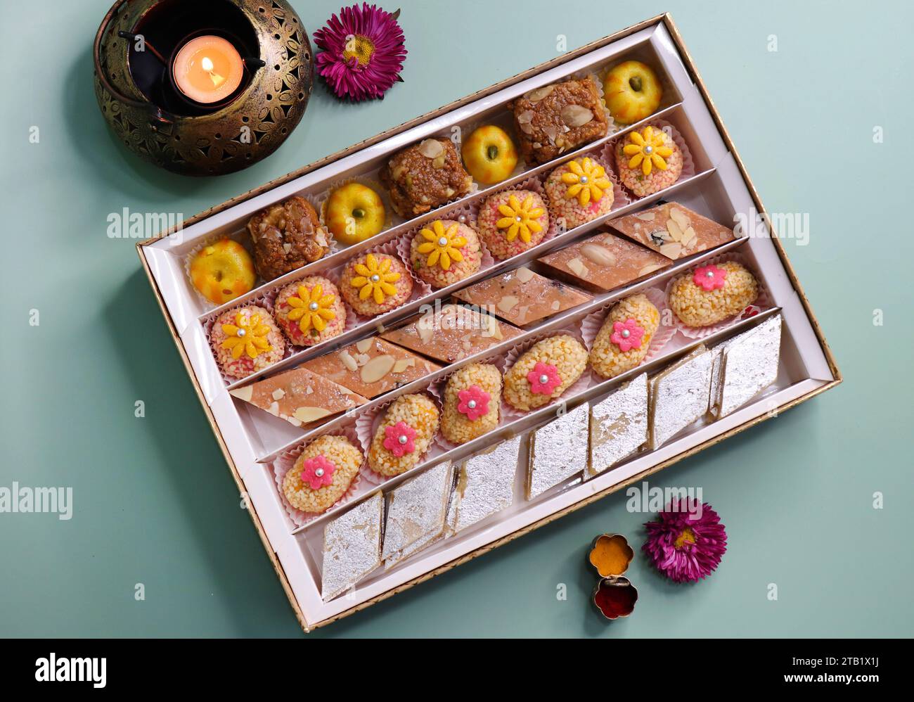 Indian assorted Diwali sweets or mithai with diya and flowers. Festive ...