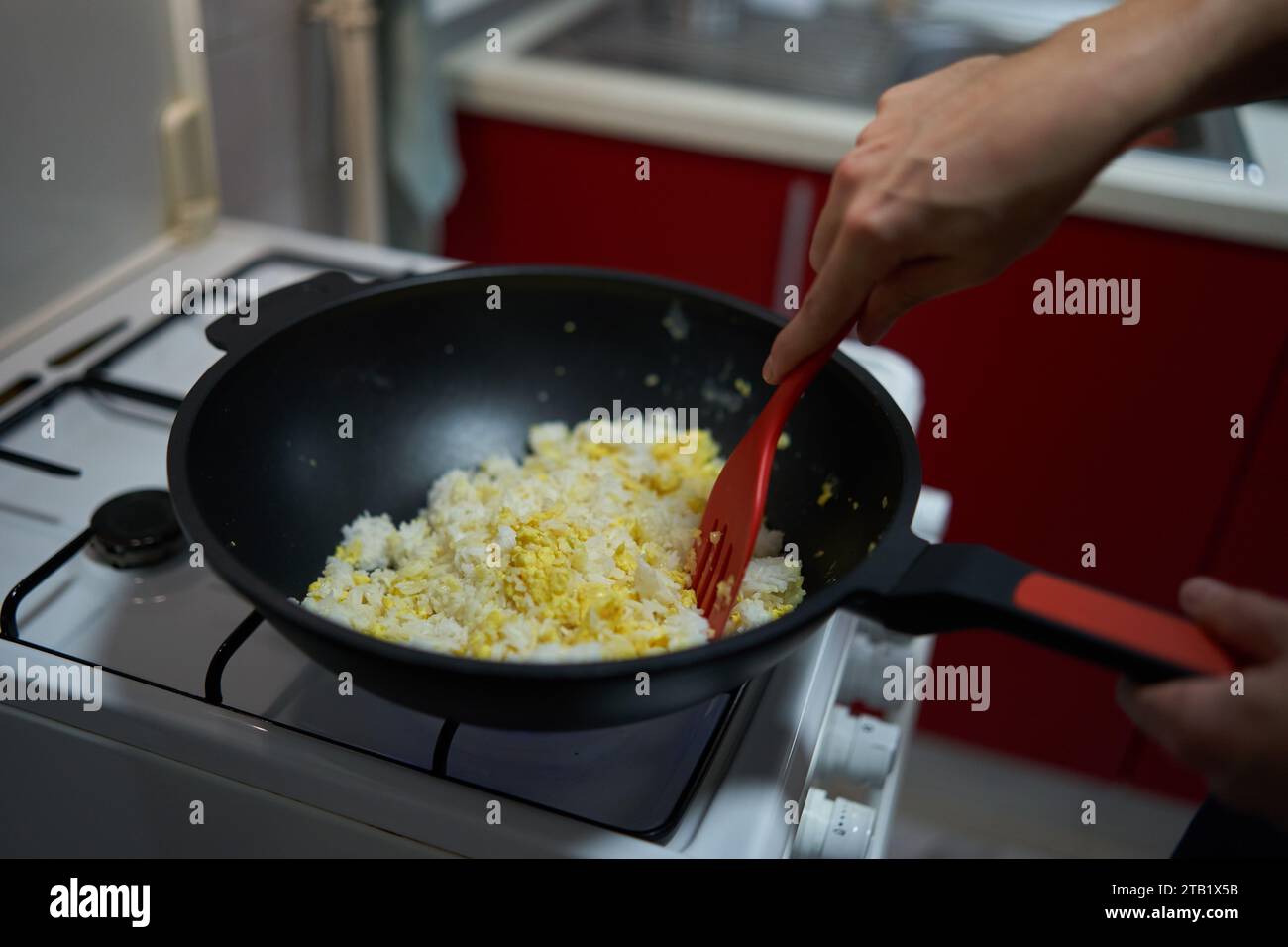 Hands of a young man making fried rice with eggs in a work, asian ...