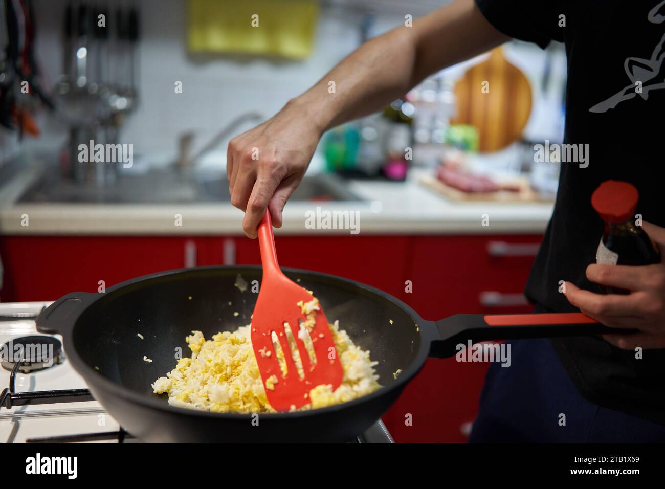 Hands of a young man making fried rice with eggs in a work, asian ...