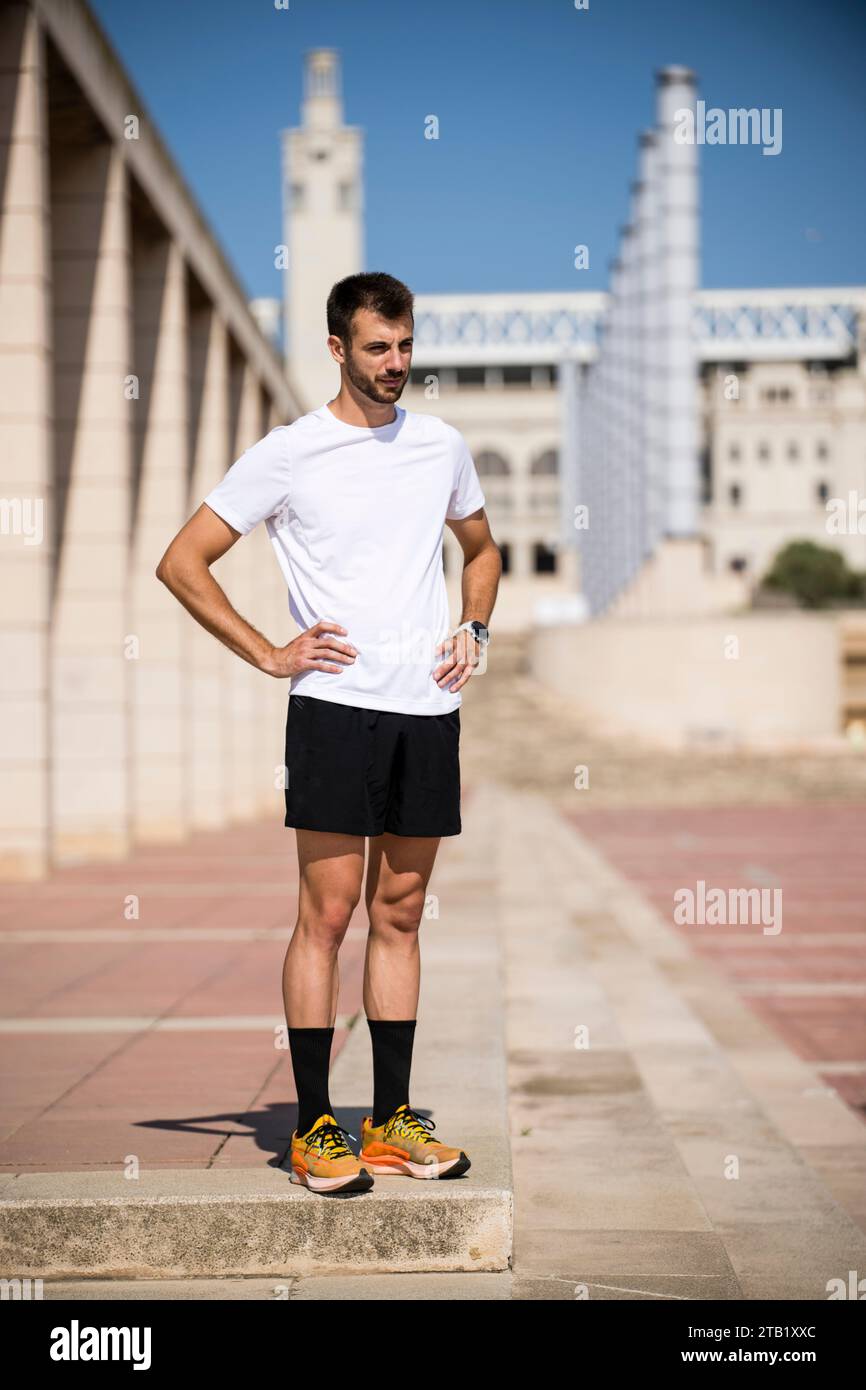 Relaxed male running athlete standing waiting for training outside ...