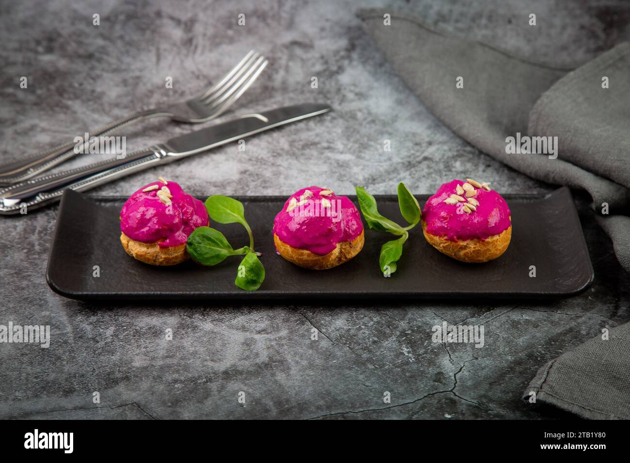 dessert of baked buns with raspberry topping and seed decorations, side ...