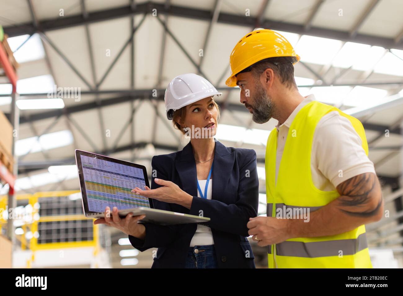 Female manager talking with foreman, checking production plan on ...
