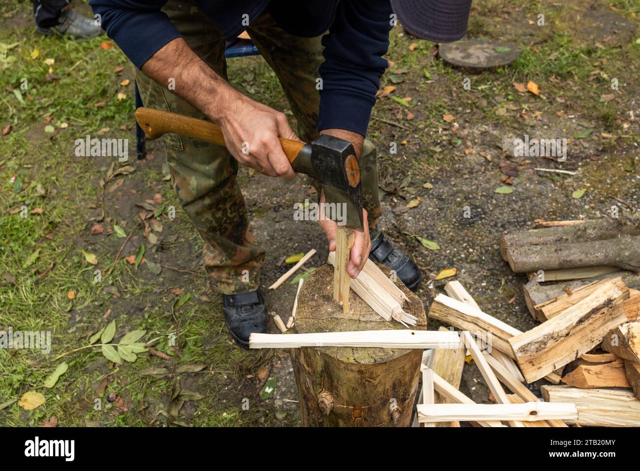 A man splits wood with an axe Stock Photo - Alamy