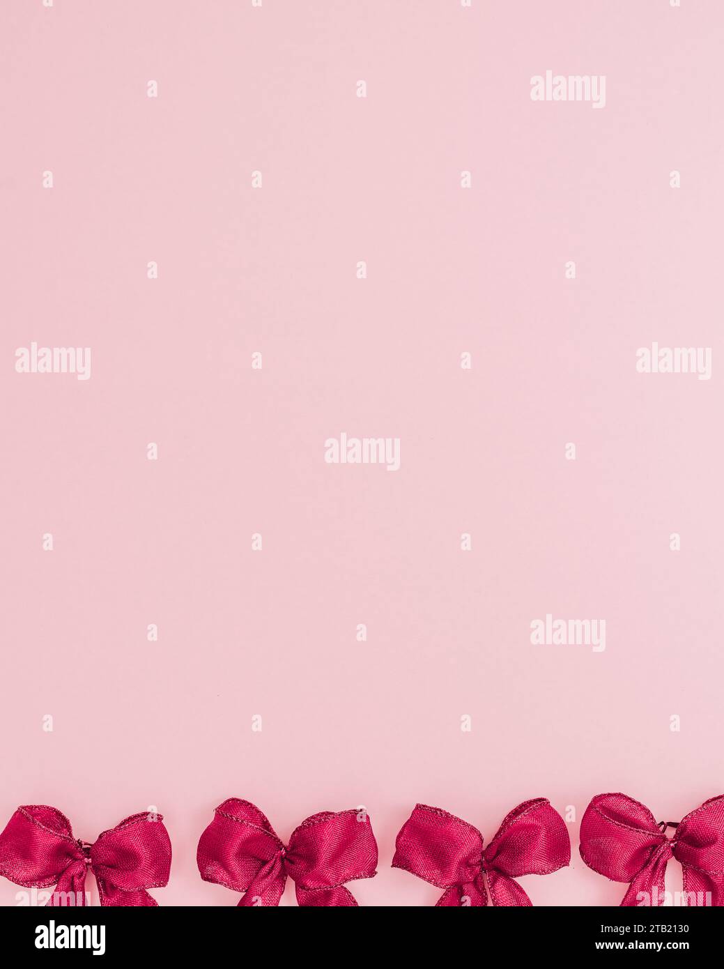 Small Red Bows on Bottom of Pink Background with Copy Space Stock Photo ...