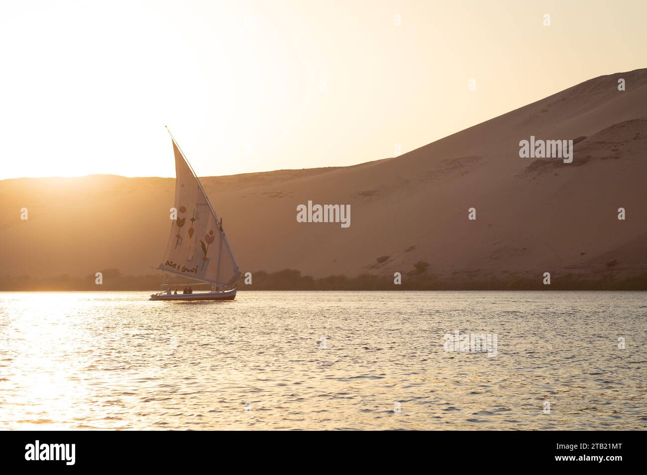 Felucca sailing the Nile River and sand dunes behind, Aswan Stock Photo ...