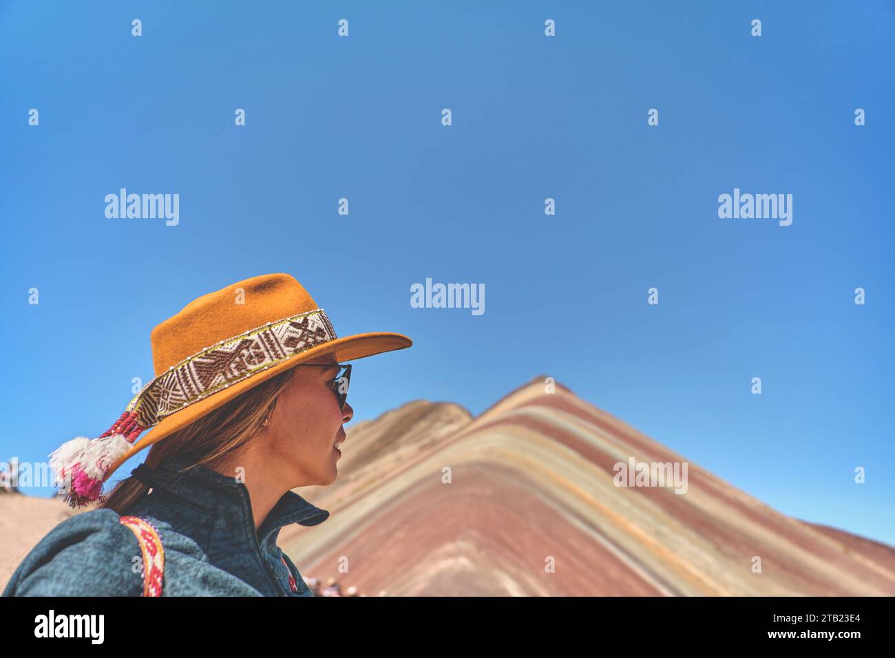 Woman standing in the rainbow mountain in Peru with all the colors of ...