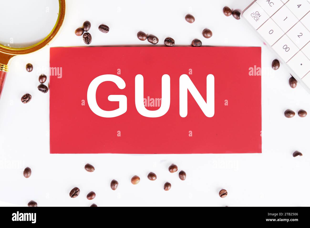GUN writing on a red card on a white background with coffee beans and a ...