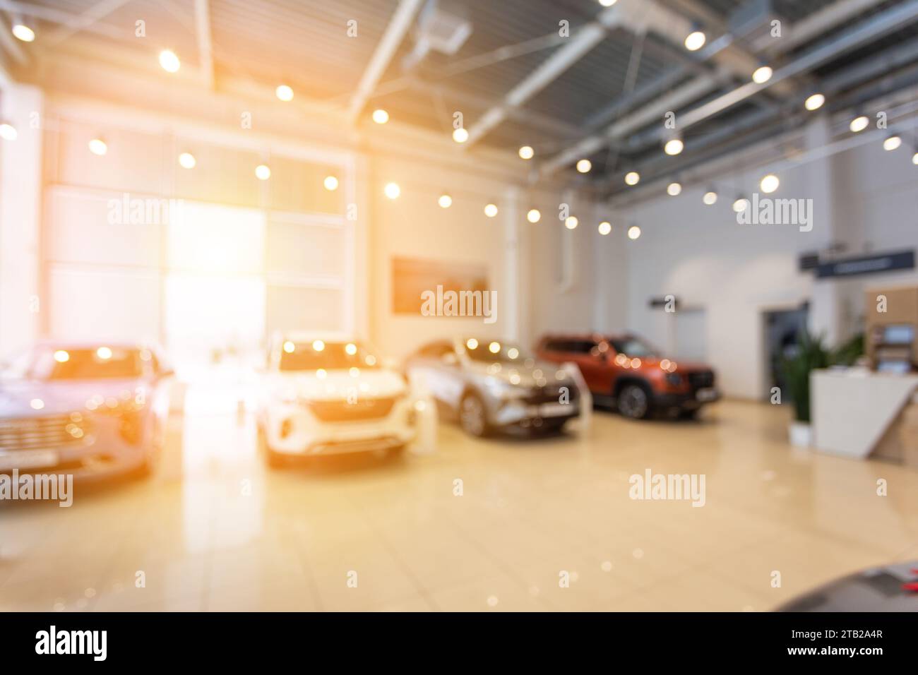 Blurred new car parked in modern showroom waiting for sales. Abstract ...