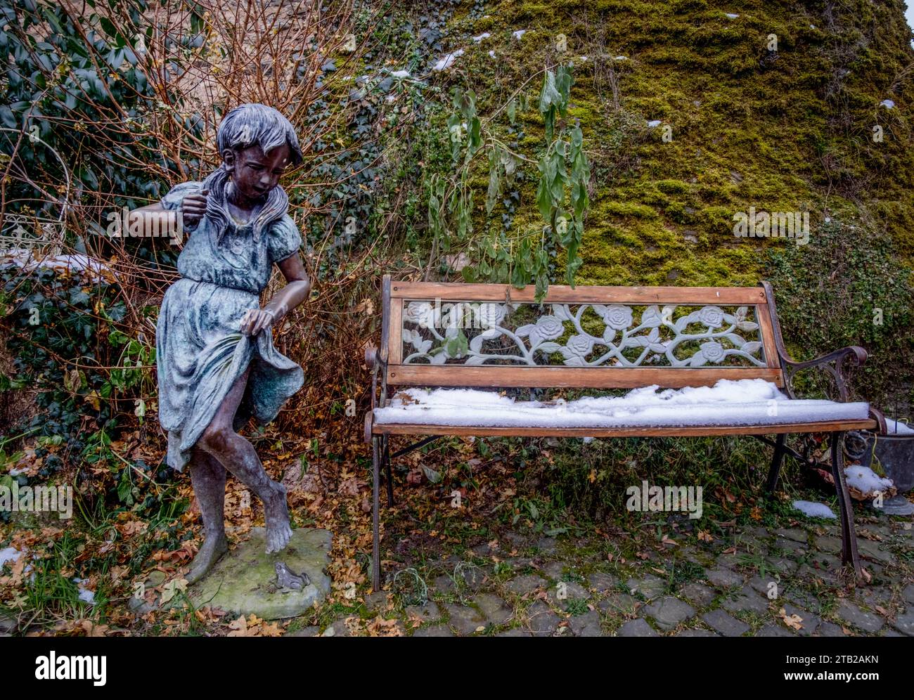A statue and a bench stand in the garden of Kransberg Castle in the ...