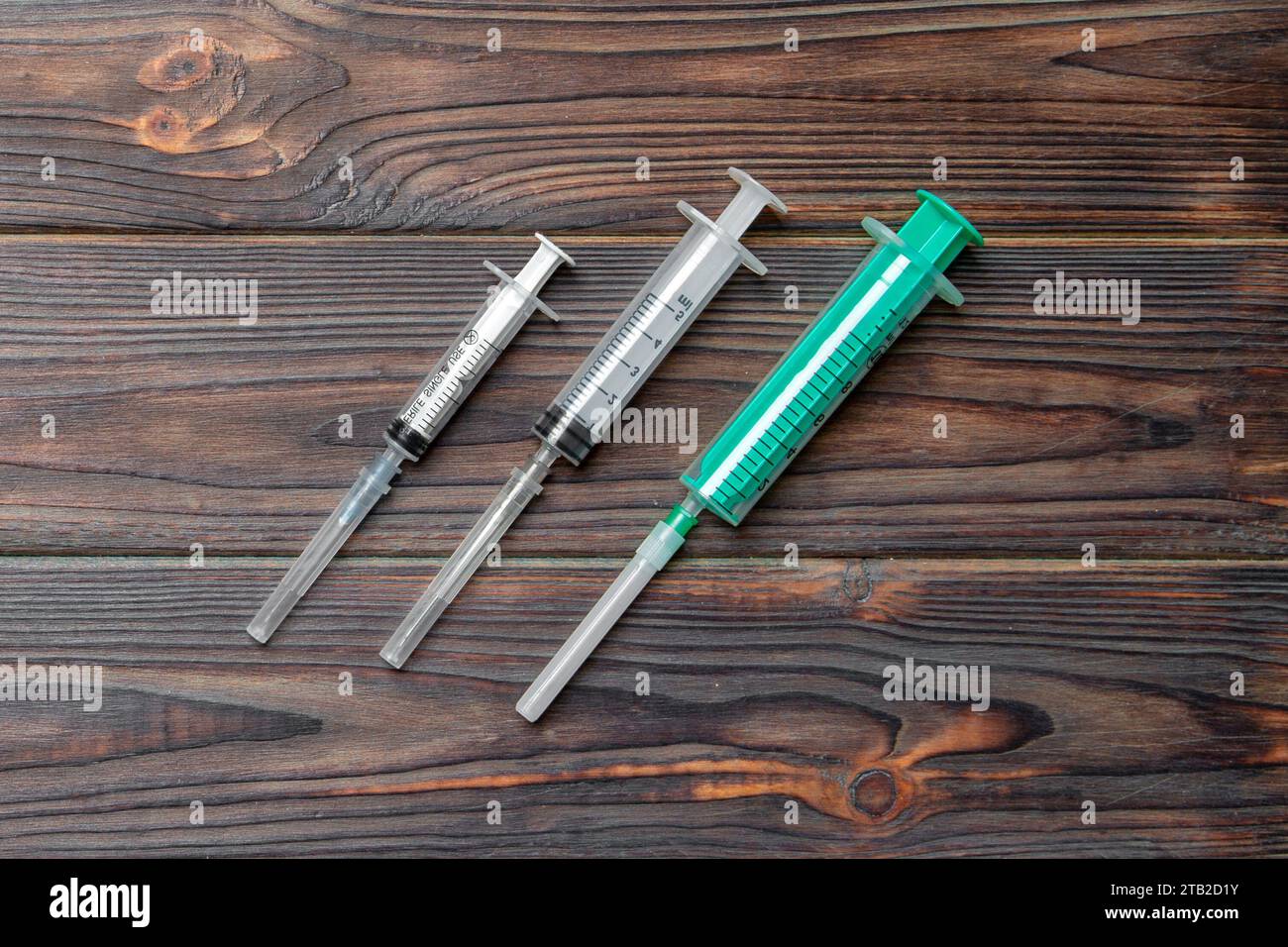 Top view of syringes of different sizes on wooden background. Medical ...