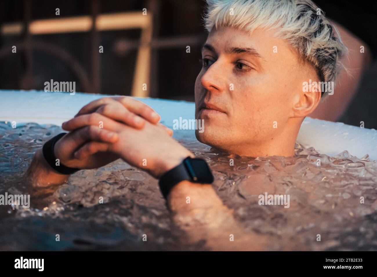 Handsome boy or man ice bathing in the cold water among ice cubes. Wim ...