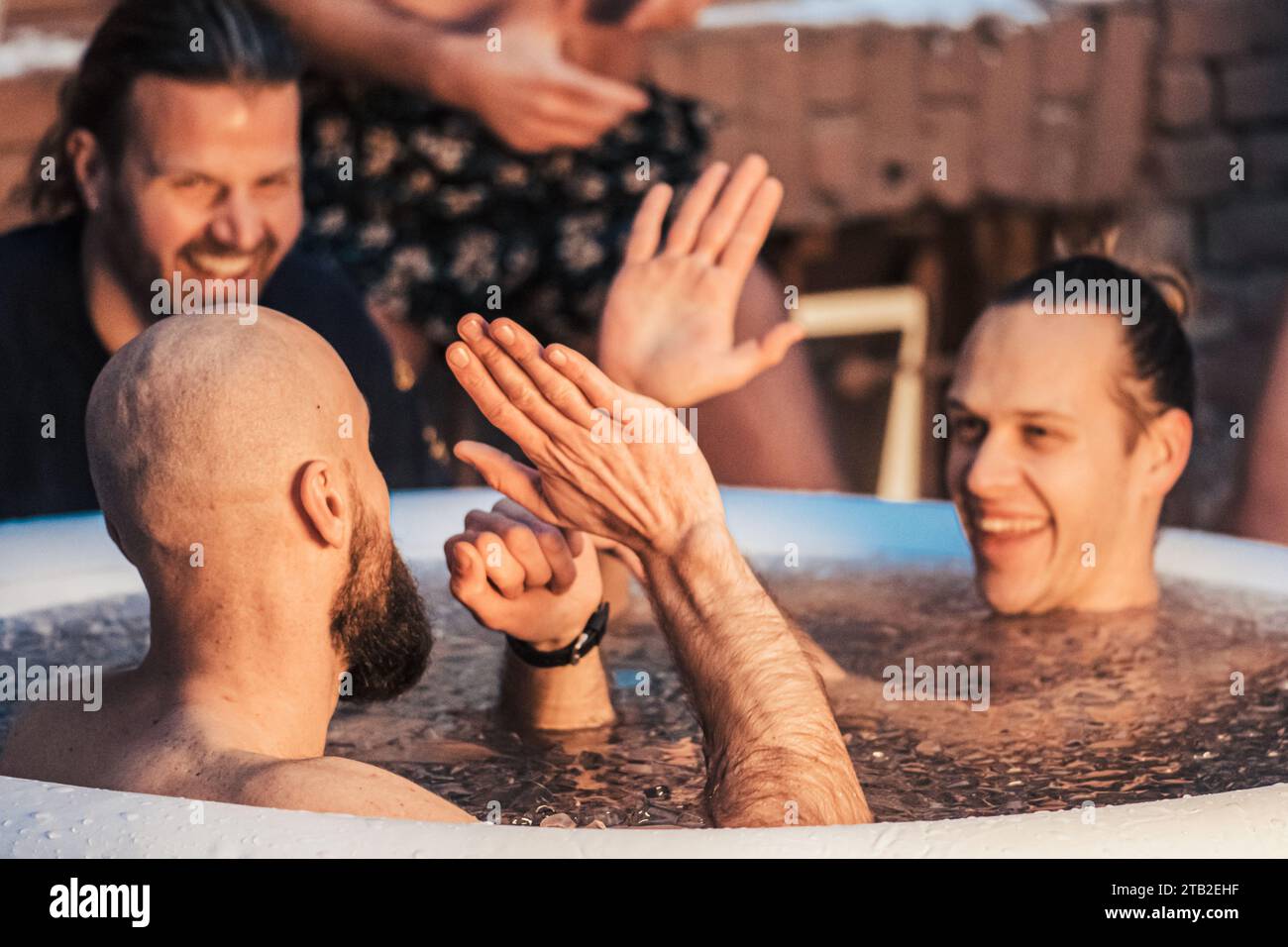 Couple of boys ice bathing in the cold water in an inflatable pool with ...