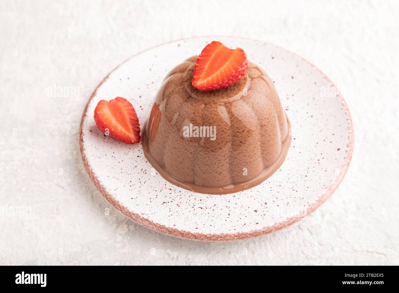 Chocolate jelly with strawberry on gray concrete background. side view ...