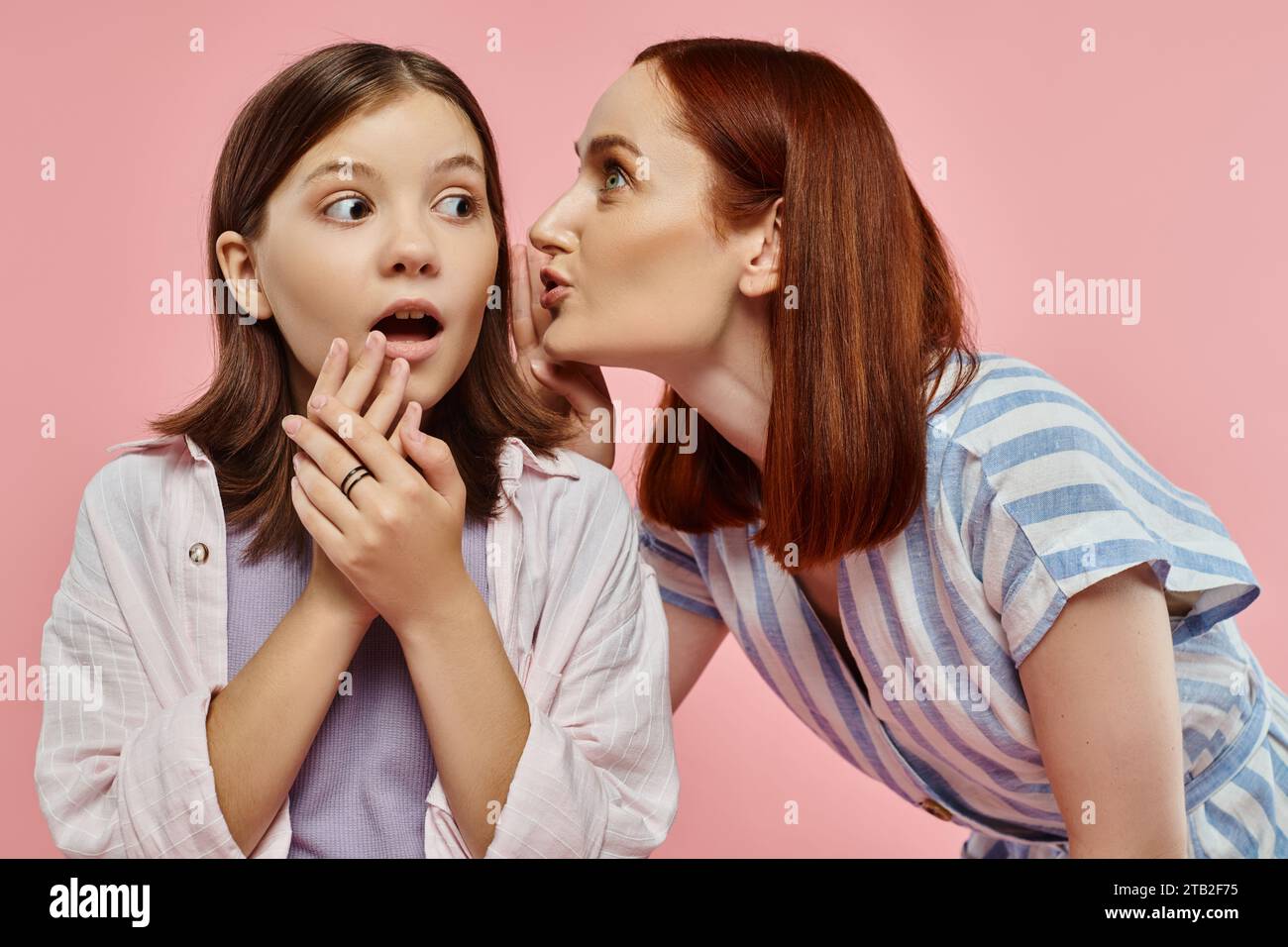 excited mother telling secret to amazed teenage daughter with open ...