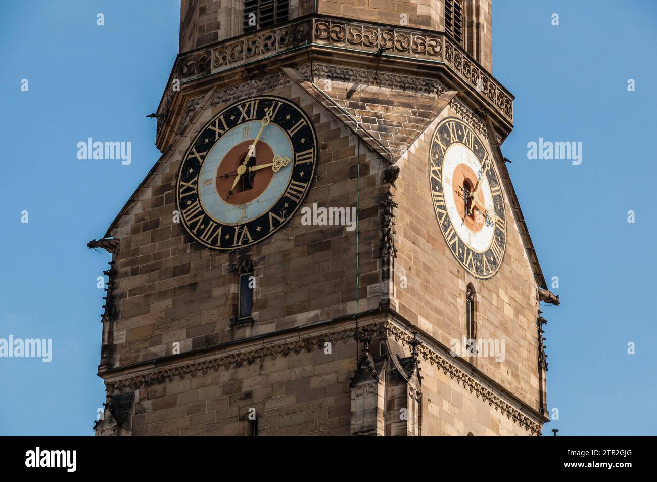 The clock tower of Stiftskirche against the backdrop of a blue sky ...
