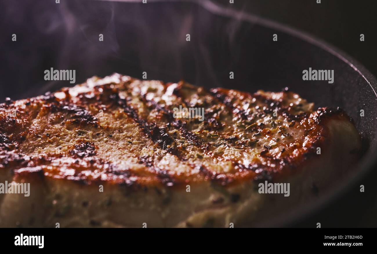 Seasoned tomahawk steak is cooked in a frying pan Stock Photo - Alamy
