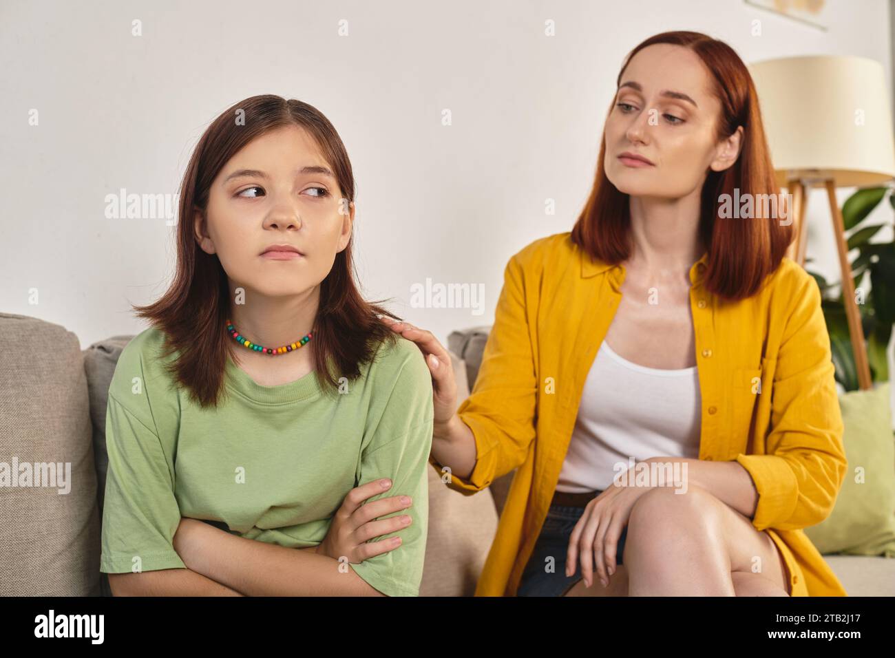 caring mother calming frustrated teenage daughter on couch in living ...