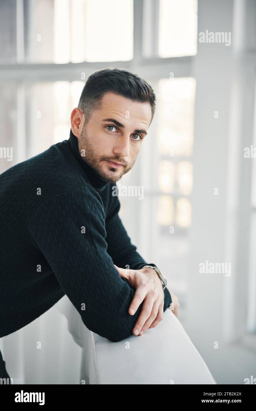 Portrait of young handsome man dressed in dark turtleneck sweater ...