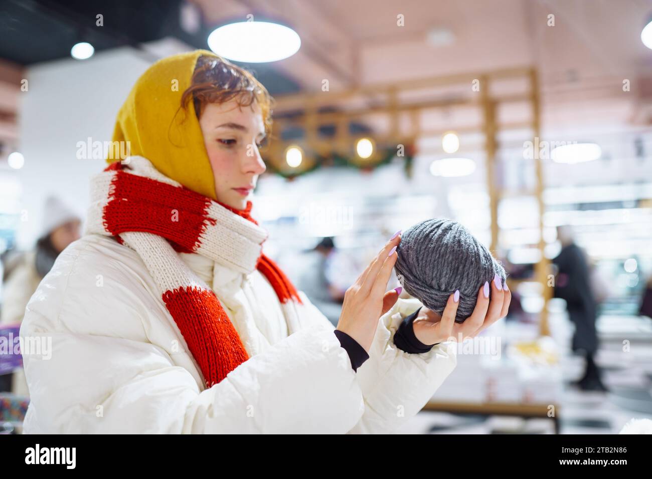 Teenage girl chooses knitting threads in store Stock Photo - Alamy