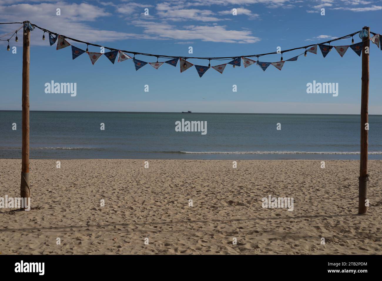 Sandy beach view with cargo ship in distance Stock Photo - Alamy